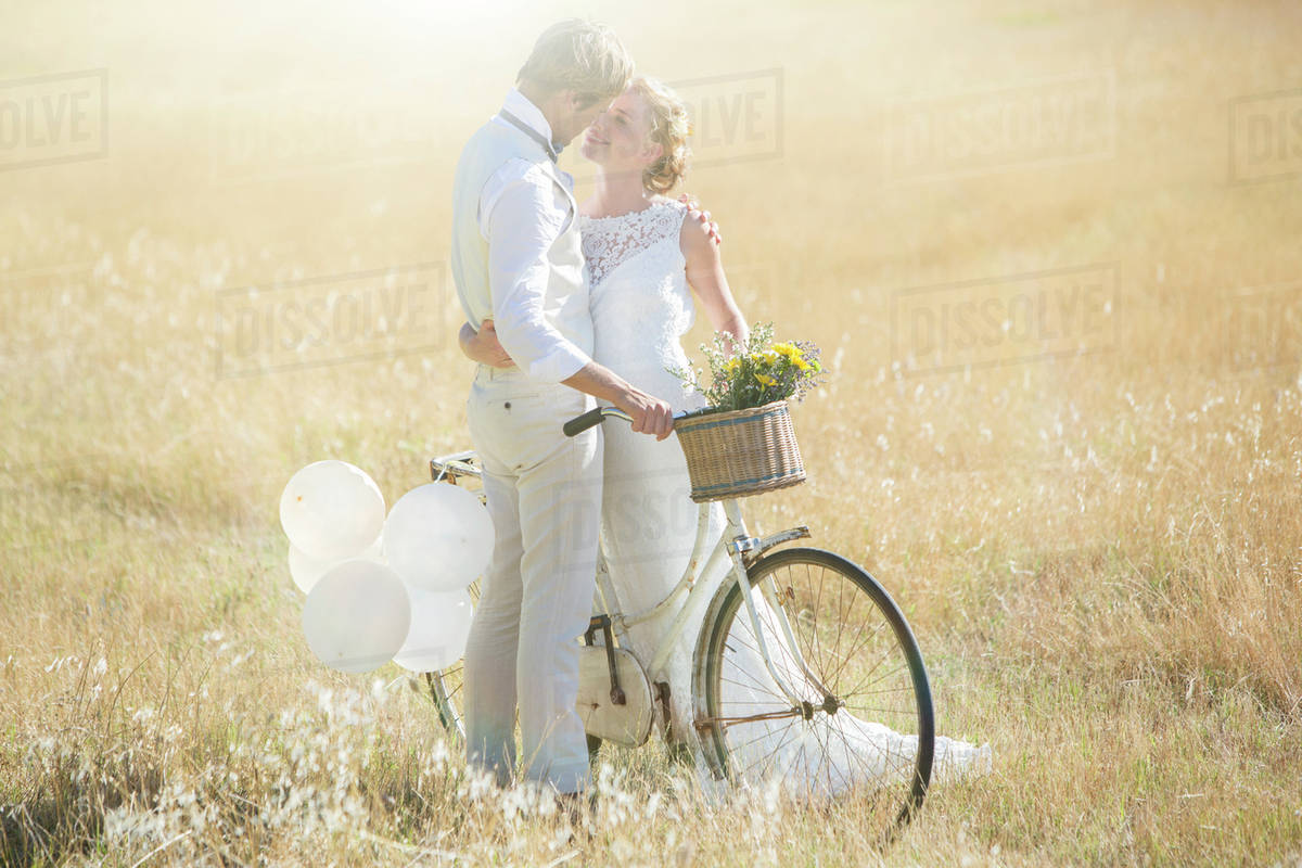 Young couple with bike kissing in meadow - Royalty-free Stock Photo ...