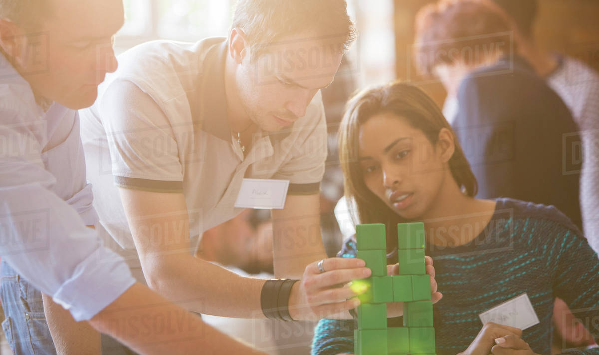 Business people stacking green blocks - Royalty-free Stock Photo | Dissolve