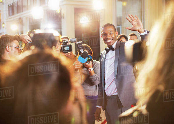 Celebrity waving for paparazzi with cameras at event - Stock Photo ...