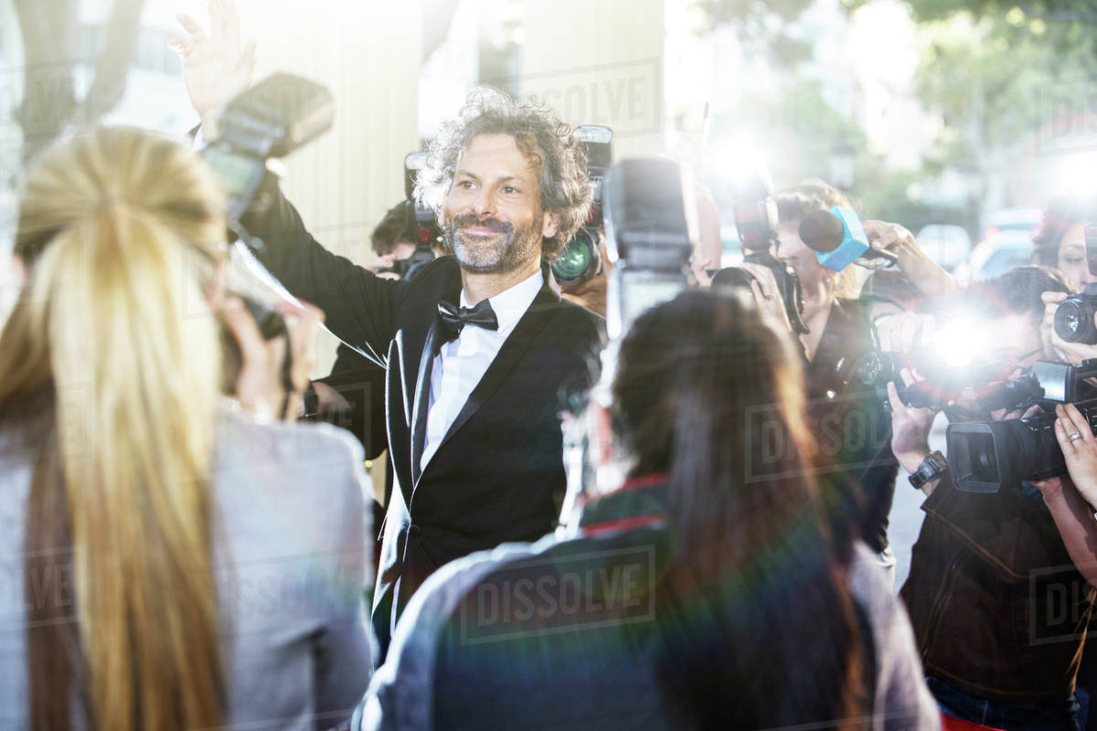 Celebrity waving at paparazzi photographers at event - Stock Photo ...