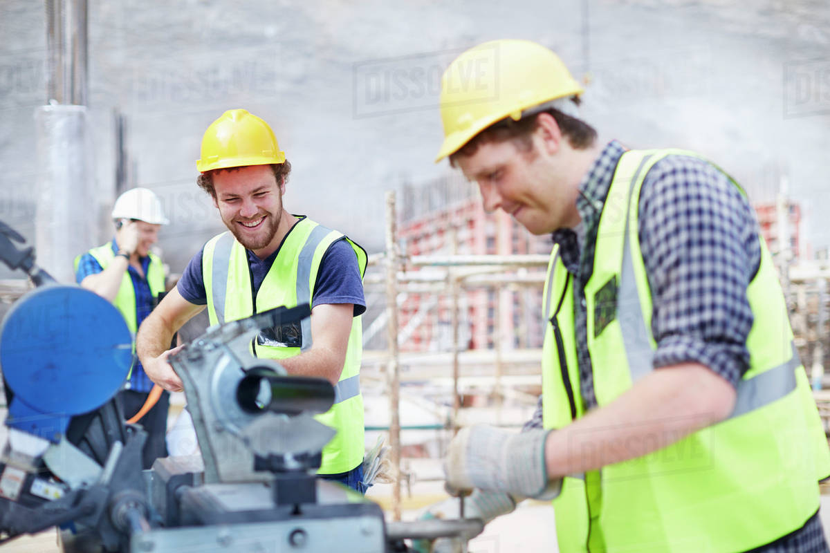 Construction workers using equipment at construction site - Stock Photo ...