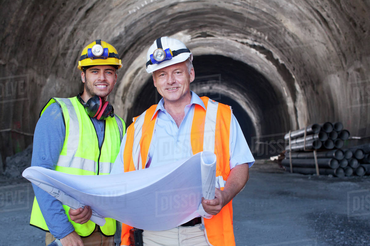 Workers reading blueprints in tunnel - Royalty-free Stock Photo | Dissolve
