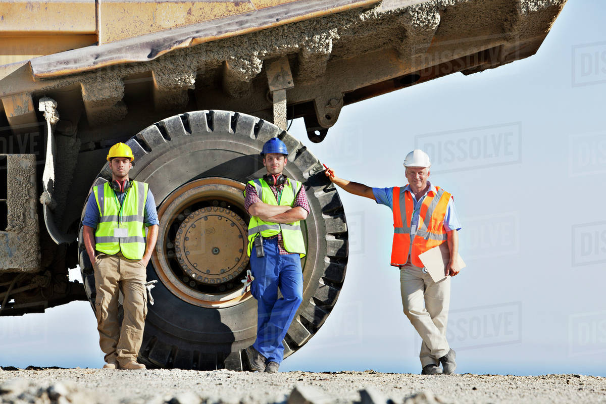 Workers standing by machinery on site - Royalty-free Stock Photo | Dissolve