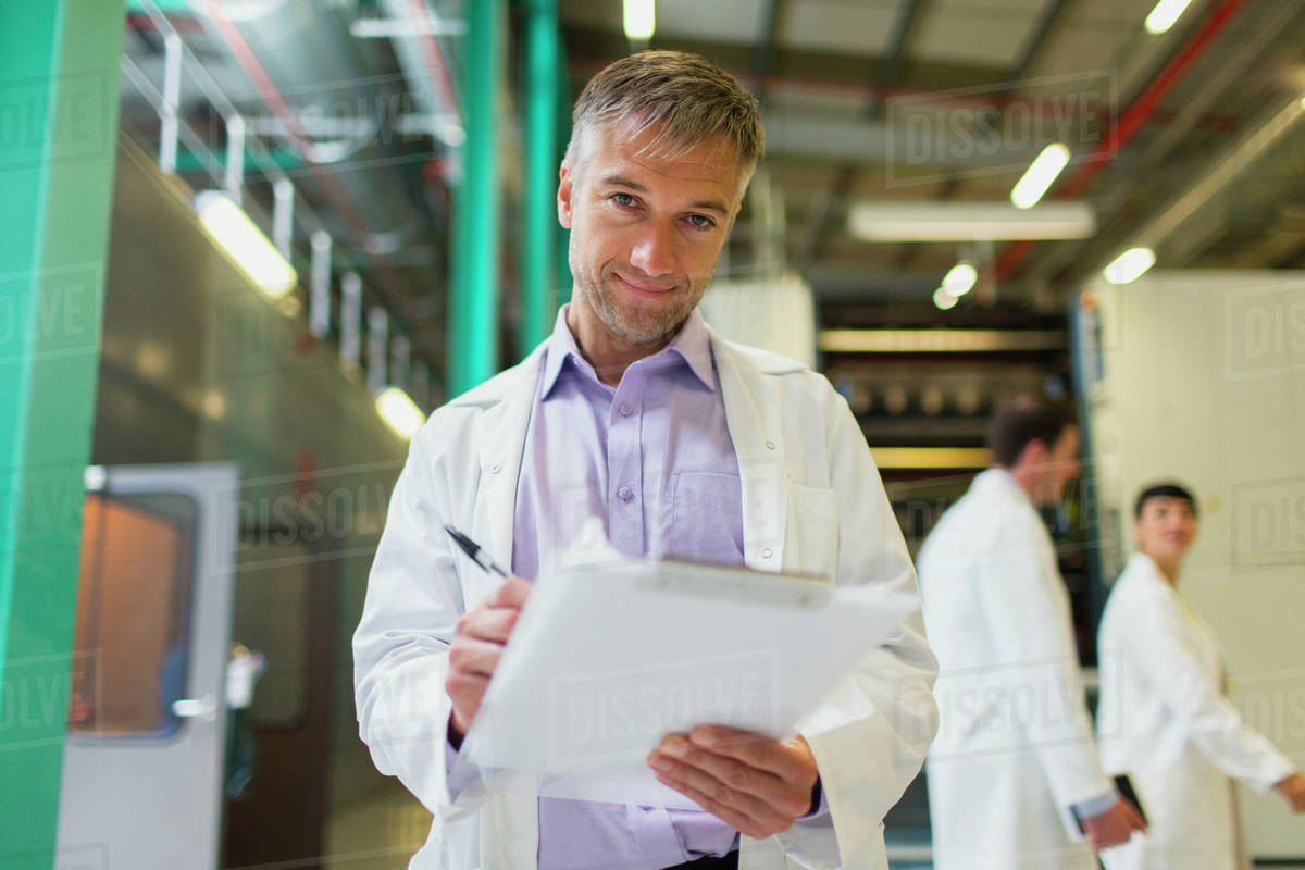 Portrait confident scientist with clipboard in factory - Royalty-free ...