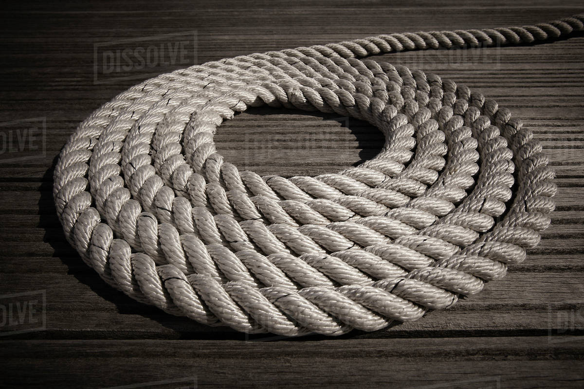 Rope coiled in circle on boardwalk - Royalty-free Stock Photo | Dissolve