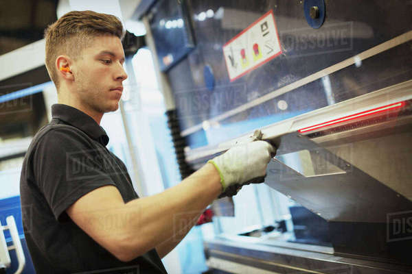 Worker operating machinery in steel factory - Stock Photo - Dissolve