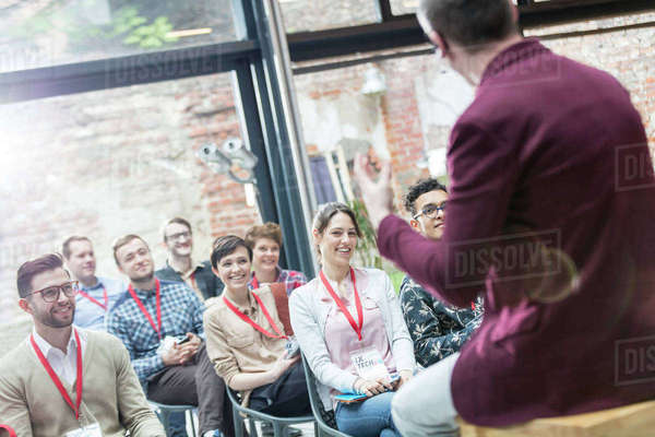 Smiling audience watching presentation at conference - Royalty-free ...