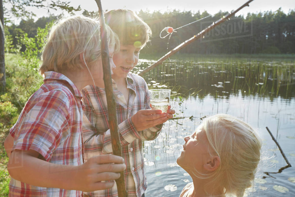 Brothers and sister fishing at sunny pond - Royalty-free Stock Photo ...