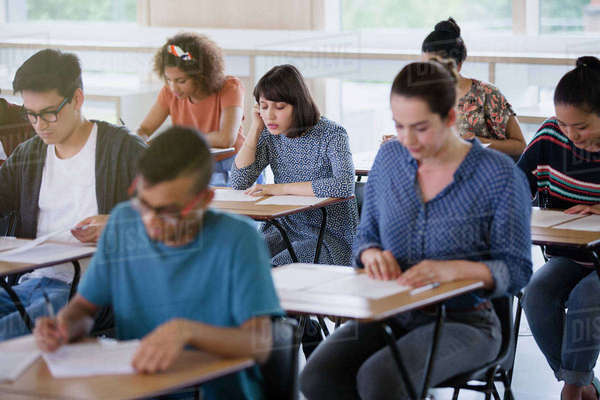 College students taking test at desks in classroom - Royalty-free Stock ...