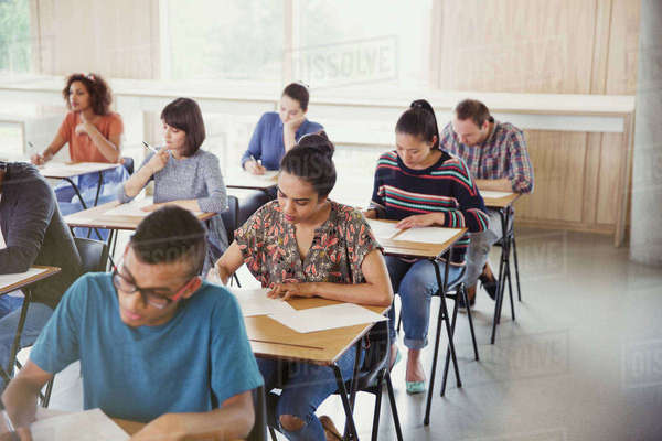 College students taking test at desks in classroom - Royalty-free Stock ...