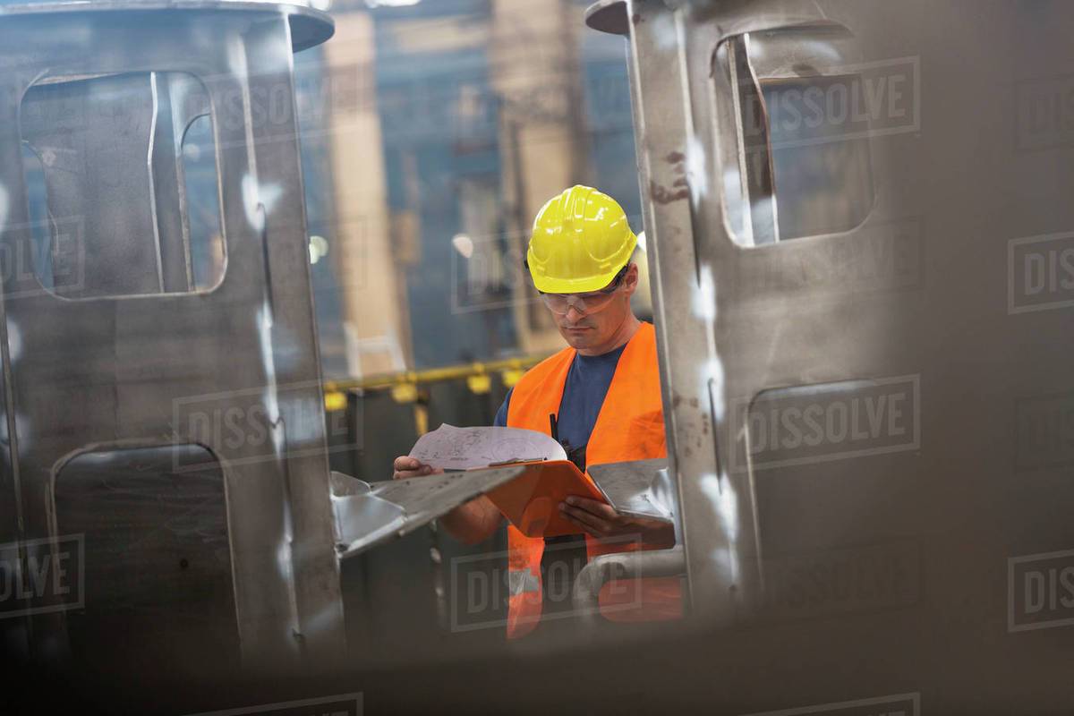 Steel worker reviewing paperwork in factory - Royalty-free Stock Photo ...