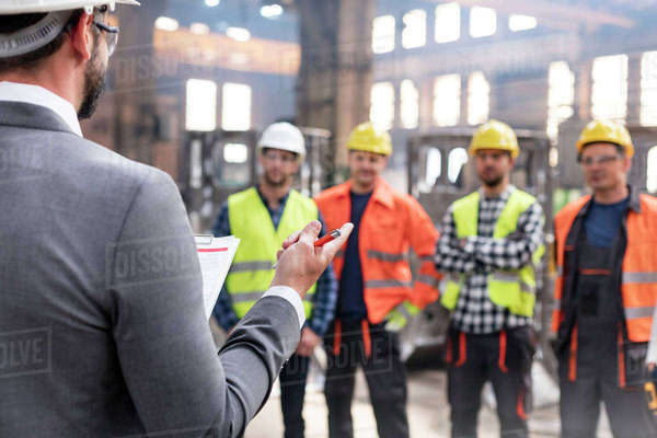 Steel workers listening to manager in meeting in factory - Stock Photo ...