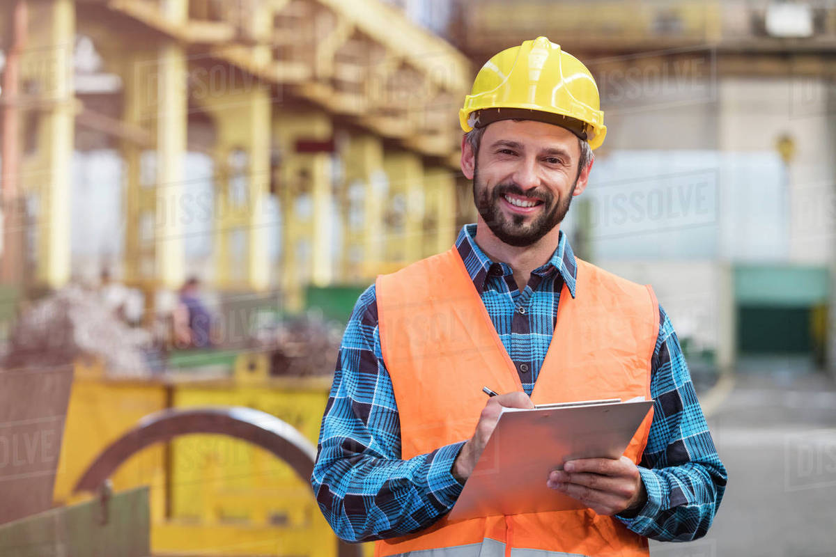 Portrait smiling steel worker with clipboard in factory - Royalty-free ...