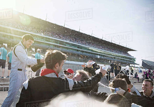 Formula one racing team and driver spraying champagne, celebrating ...