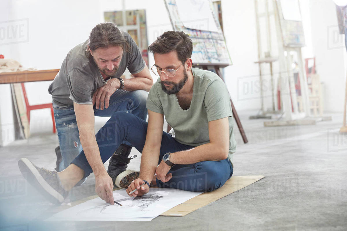 Male artists sketching on floor in art class studio - Stock Photo ...