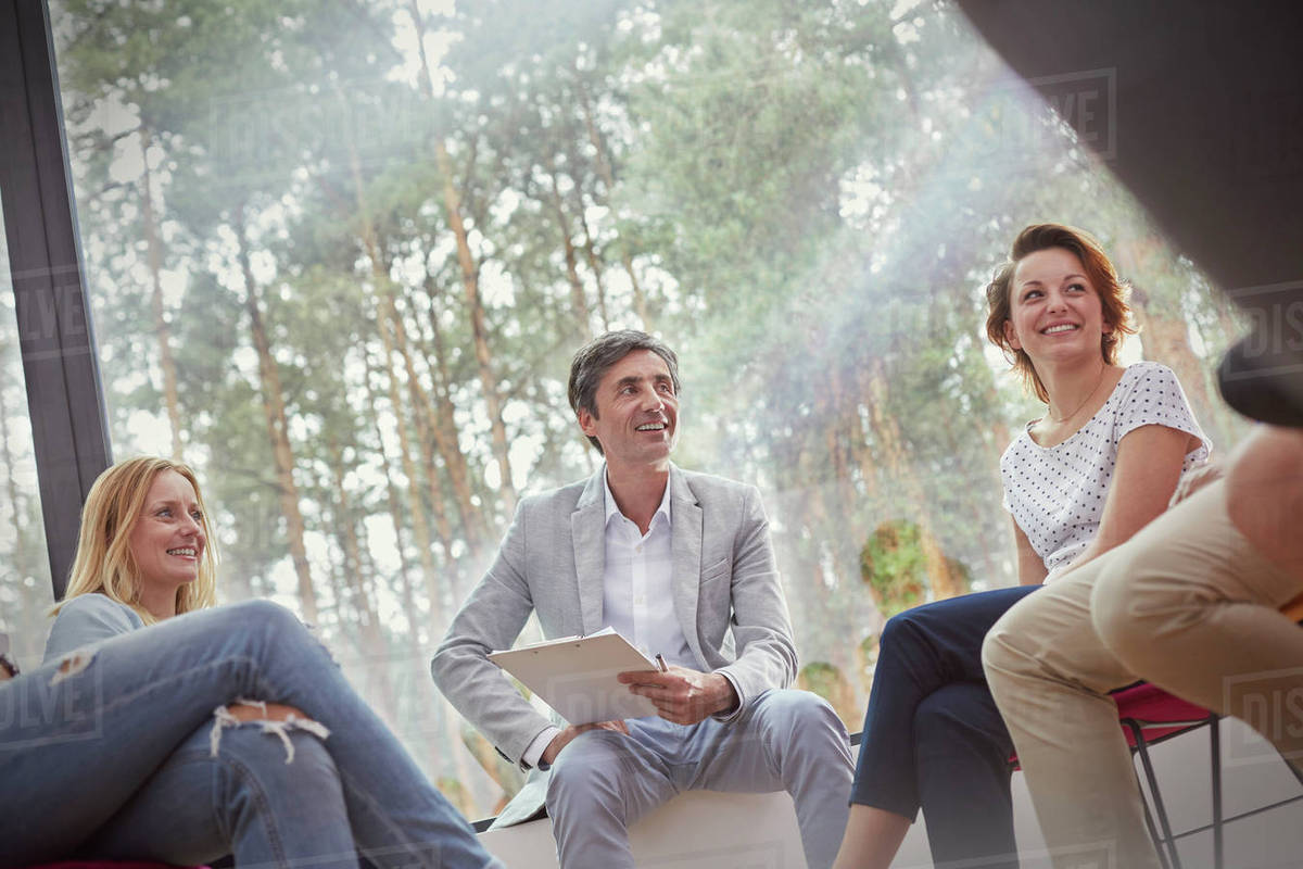 Smiling people talking in group therapy session - Royalty-free Stock ...