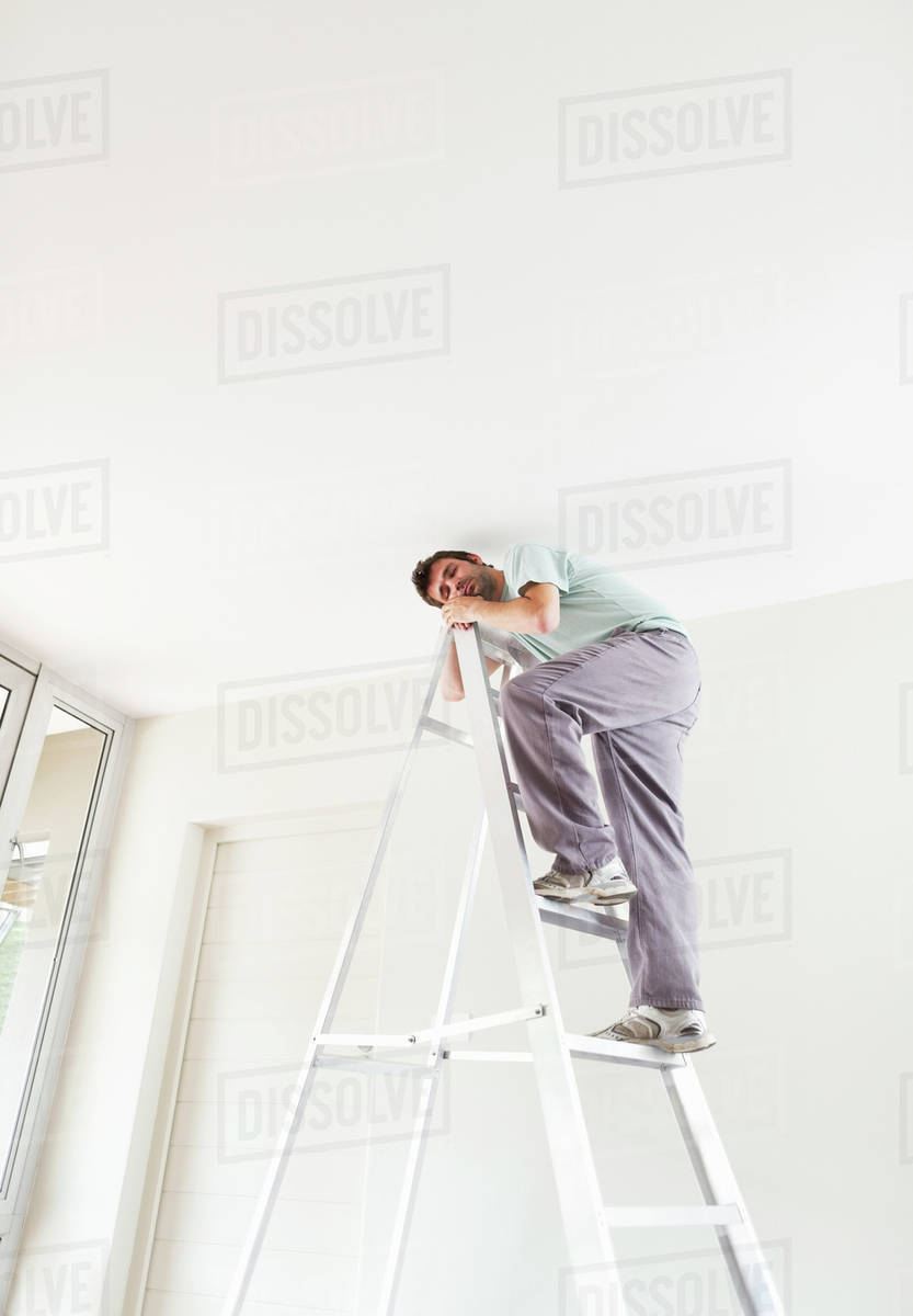 Man climbing ladder indoors - Royalty-free Stock Photo | Dissolve