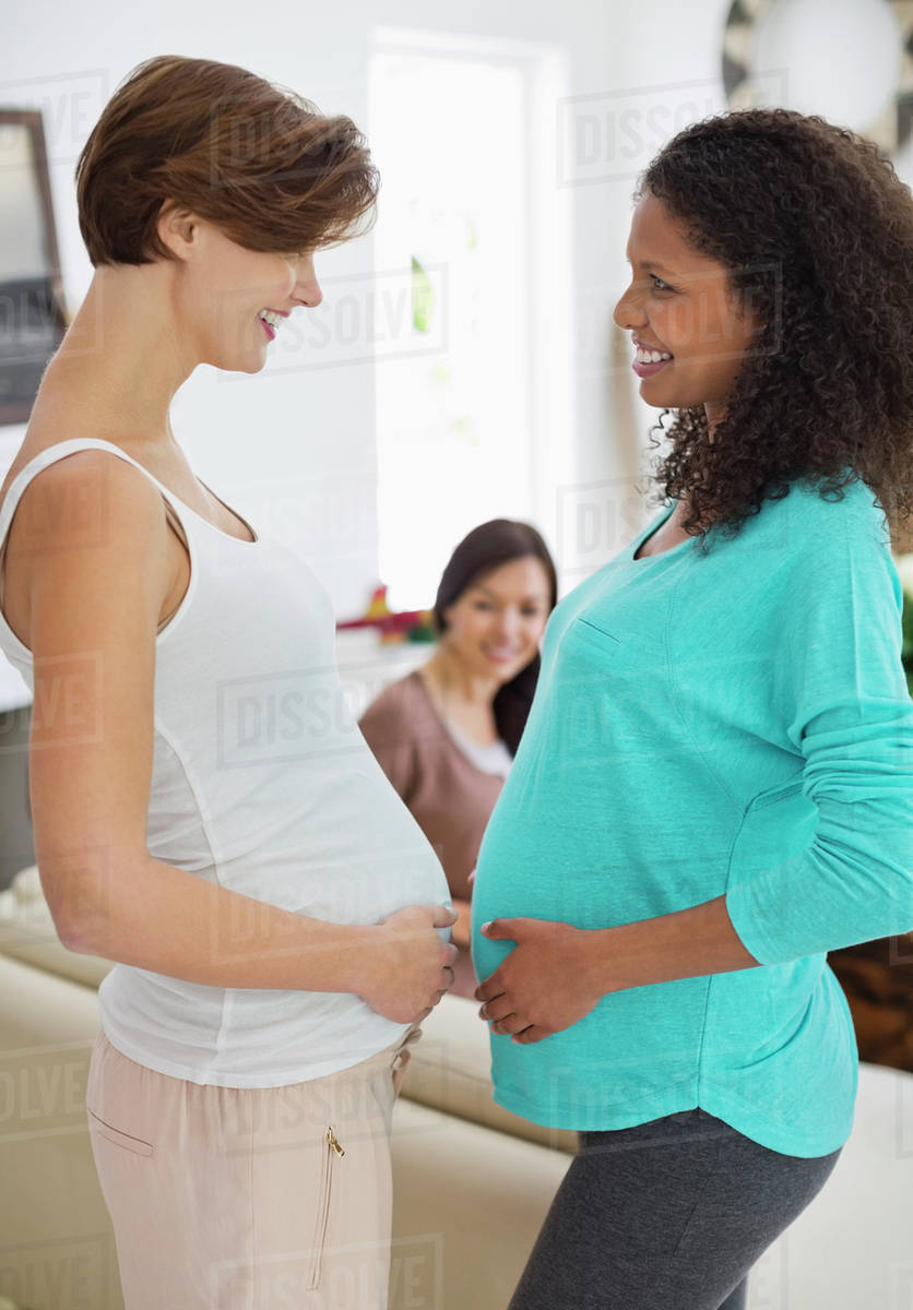 Pregnant women touching bellies - Royalty-free Stock Photo | Dissolve