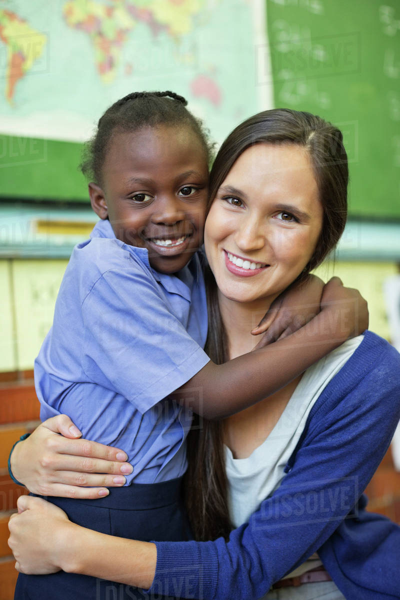 Teacher and student hugging in class - Royalty-free Stock Photo | Dissolve