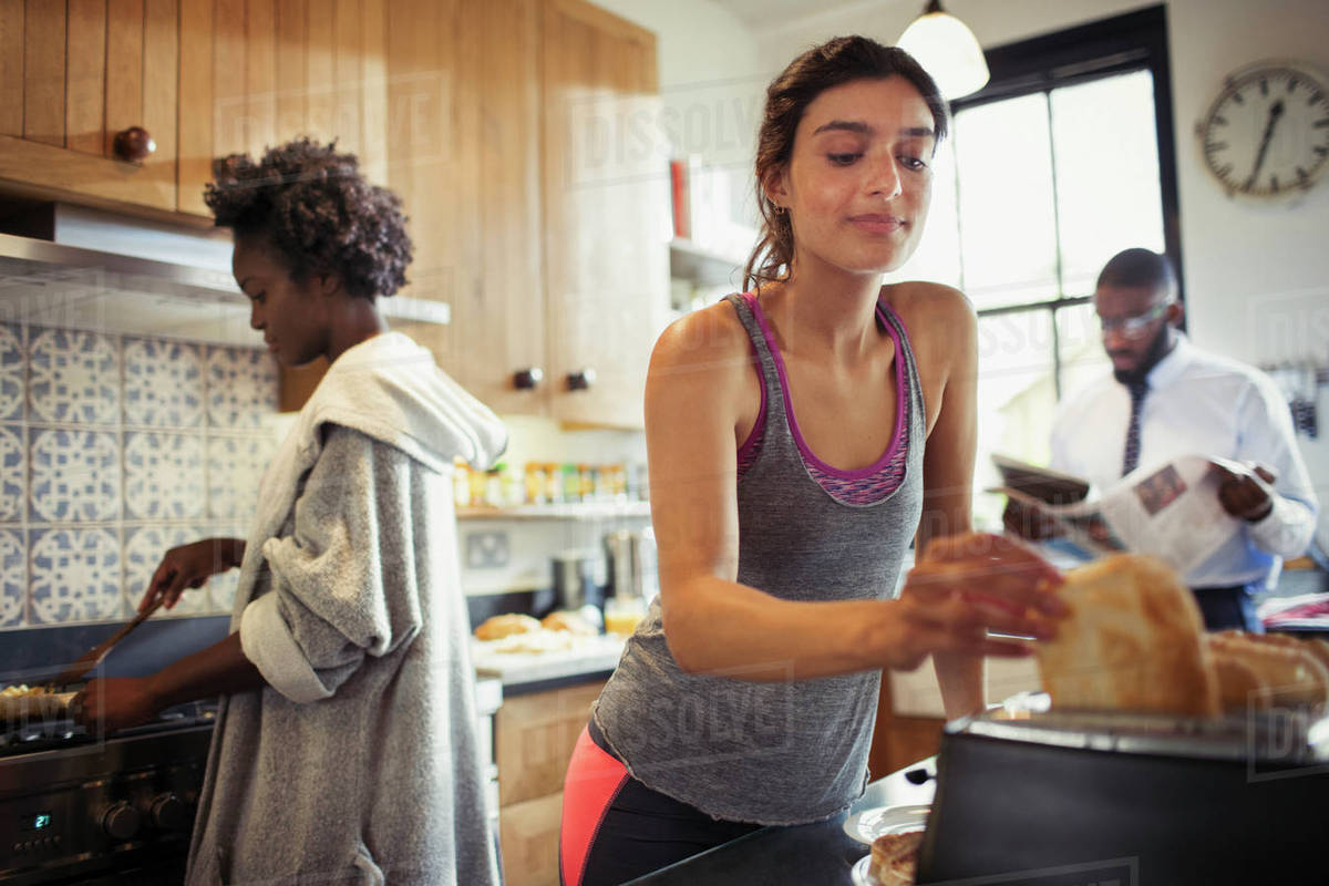 Woman toasting bread in toaster in kitchen - Royalty-free Stock Photo ...