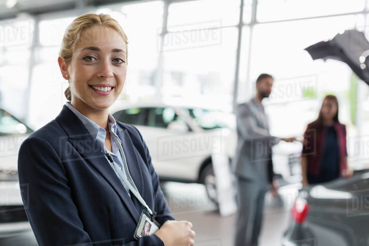 Portrait smiling, confident car saleswoman in car dealership showroom ...