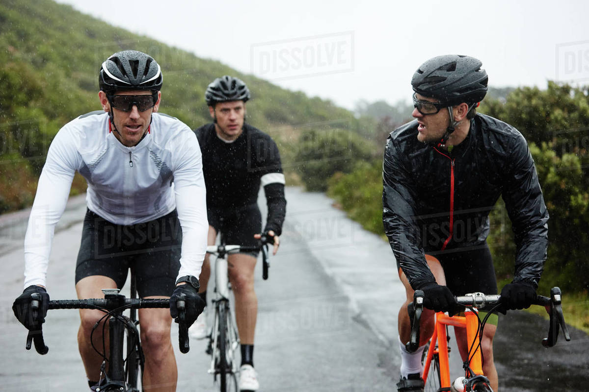 Male cyclists cycling on wet road - Royalty-free Stock Photo | Dissolve