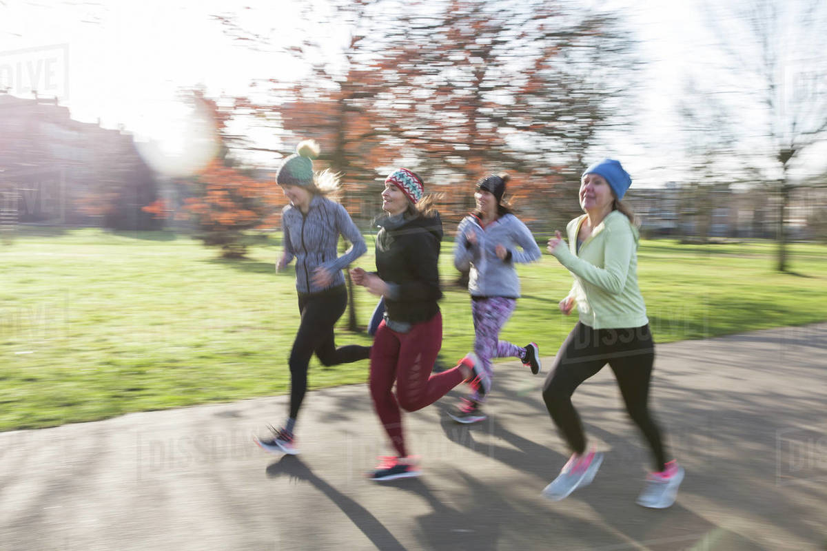 Smiling female runners running in sunny park - Royalty-free Stock Photo ...