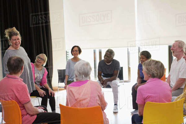 Laughing active seniors meeting in circle in community center - Stock ...