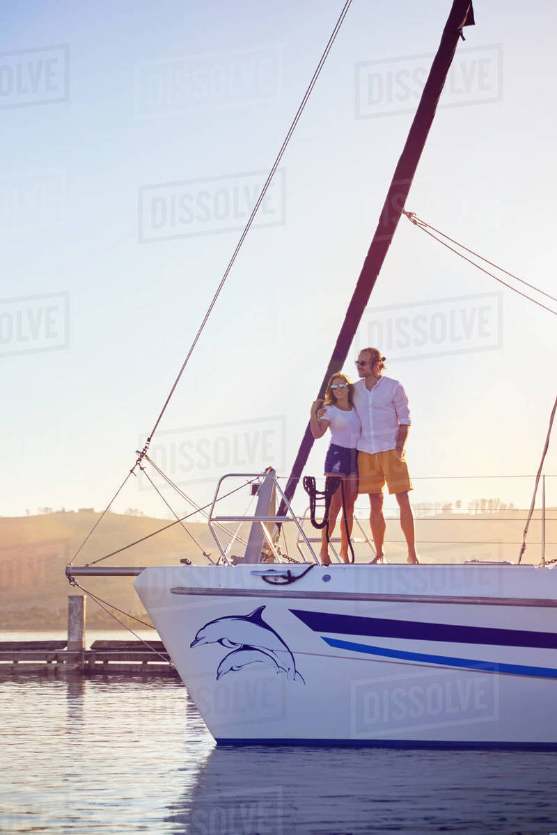 Couple hugging on catamaran - Stock Photo - Dissolve
