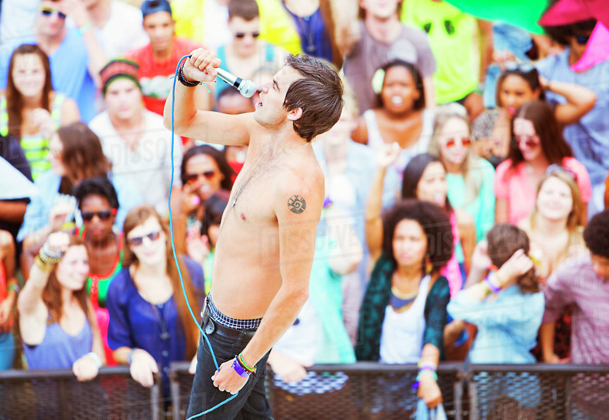 Fans watching performer sing at music festival - Stock Photo - Dissolve