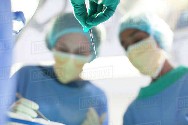 Surgeons working in operating room - Stock Photo - Dissolve
