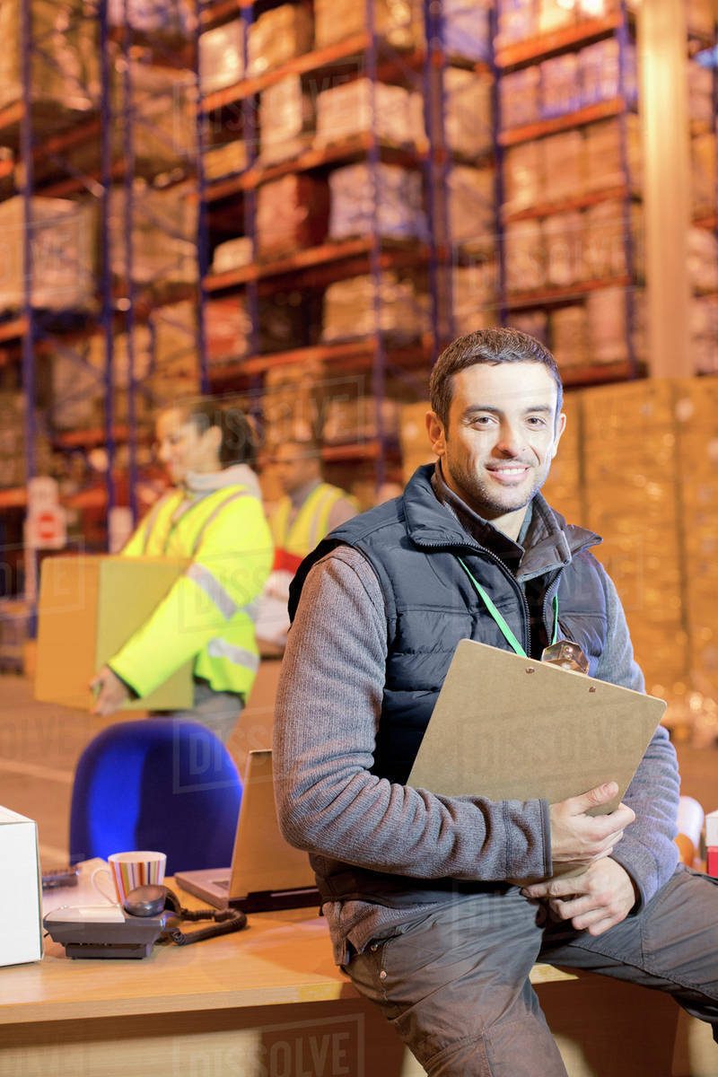 Worker smiling in warehouse - Royalty-free Stock Photo | Dissolve