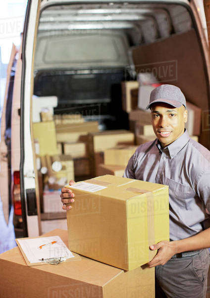 Delivery boy loading boxes into van - Royalty-free Stock Photo | Dissolve