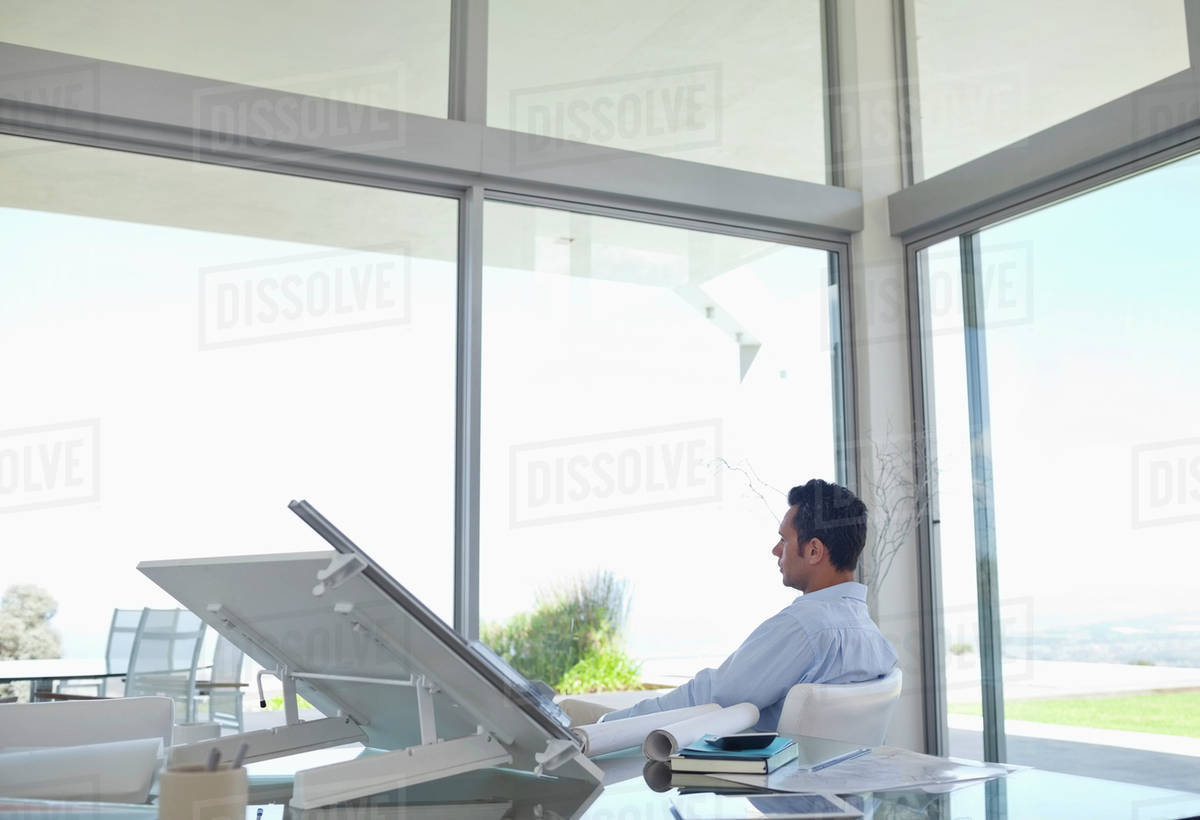 Businessman looking out office window - Stock Photo - Dissolve