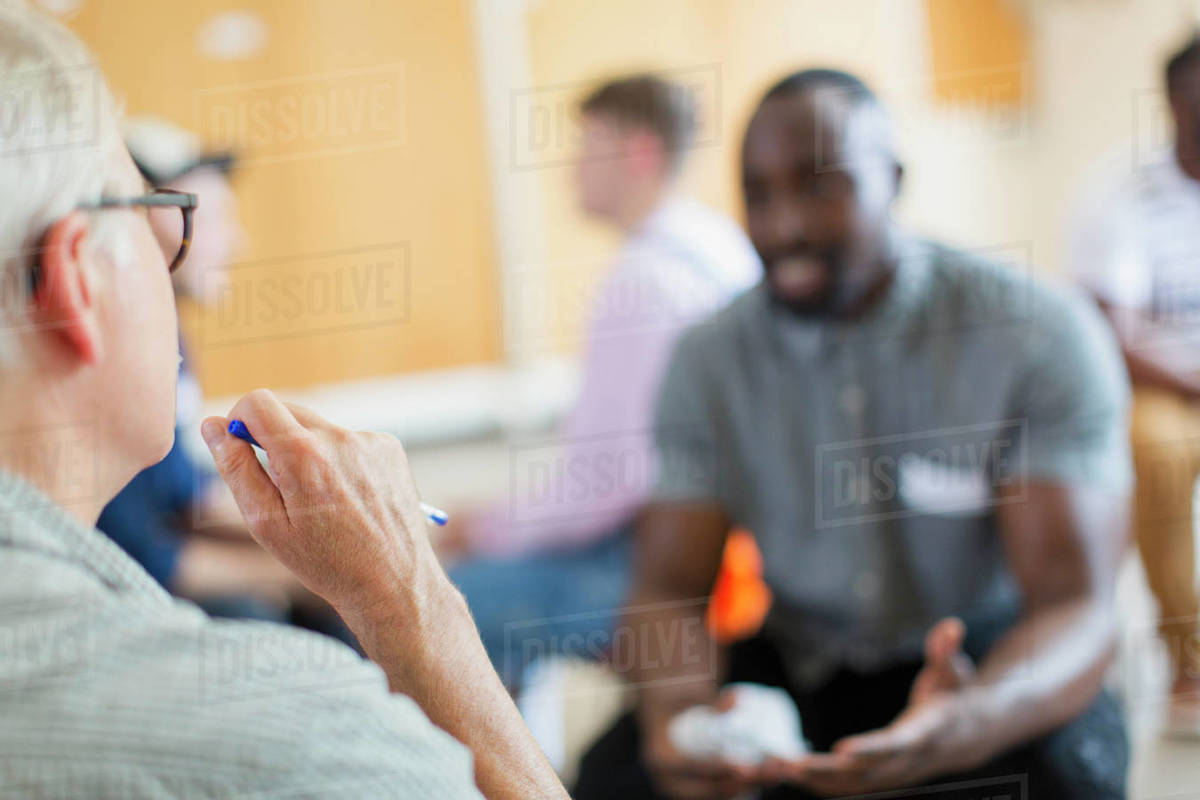 Men talking and listening in group therapy - Stock Photo - Dissolve