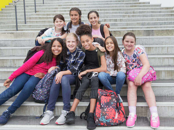 Portrait confident junior high girl students on steps - Royalty-free ...