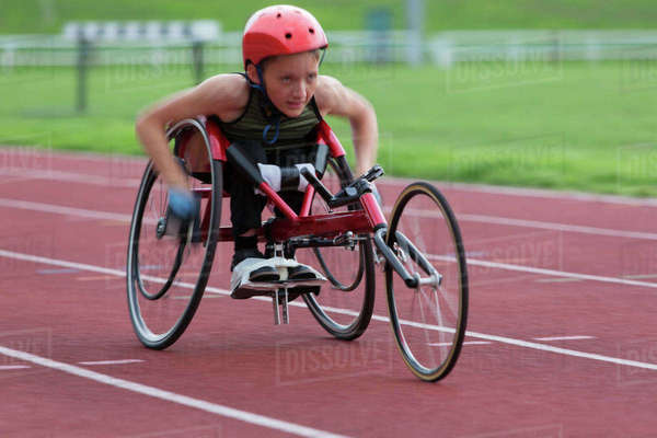 Determined, tough teenage girl paraplegic athlete speeding along sports ...