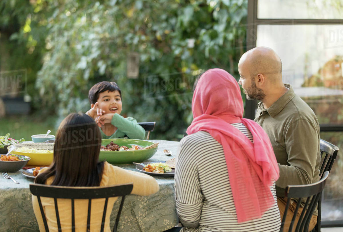Family eating dinner at table - Royalty-free Stock Photo | Dissolve