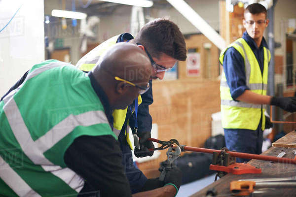 Male instructor helping students in shop class workshop - Royalty-free ...