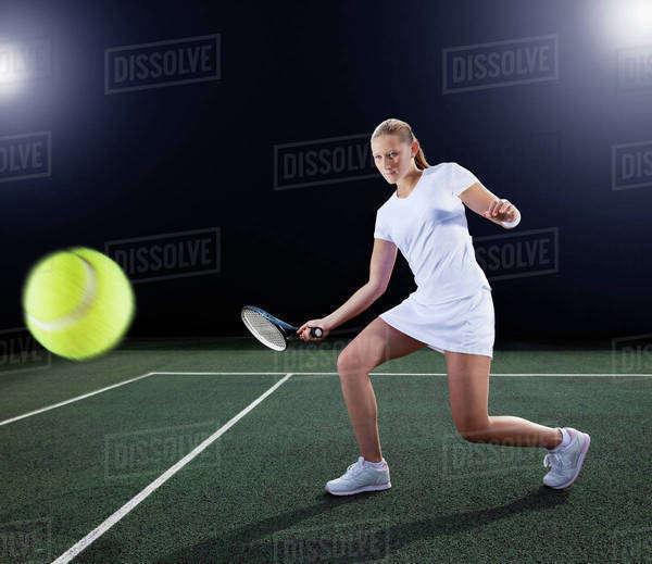 Tennis player hitting ball on court - Royalty-free Stock Photo | Dissolve