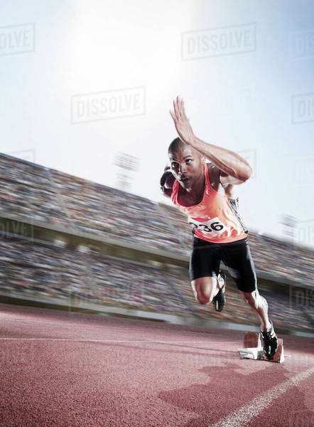 Sprinter taking off from starting block - Stock Photo - Dissolve