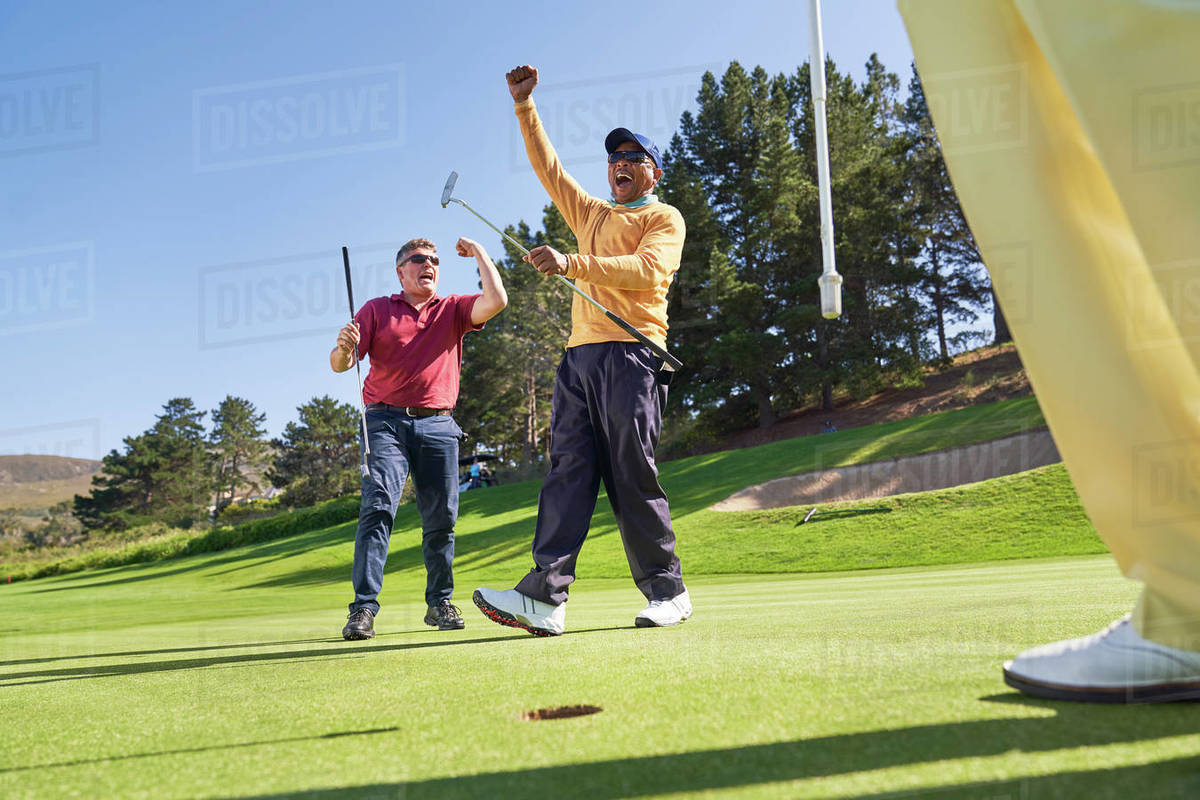 Happy male golfers cheering on sunny putting green - Royalty-free Stock ...
