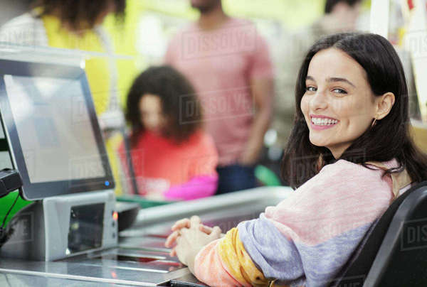 Portrait smiling, confident female cashier working at supermarket ...