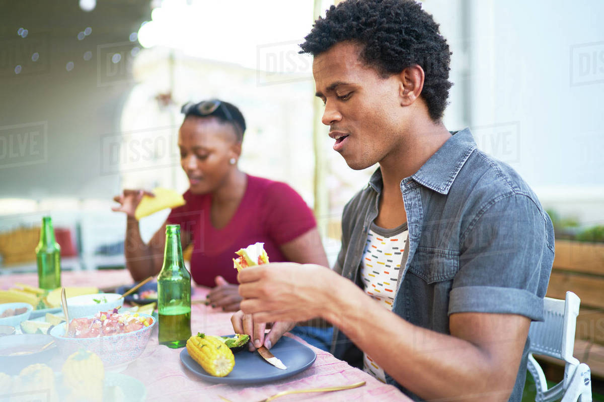 Young man eating taco lunch at patio table - Royalty-free Stock Photo ...