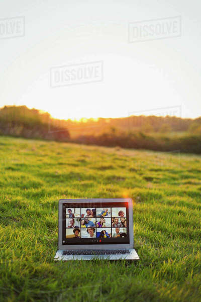 Friends video chatting on laptop screen in sunny grass field - Stock ...