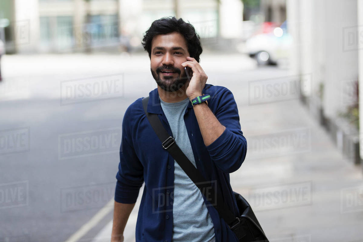 Man with smart phone walking on sidewalk - Royalty-free Stock Photo ...