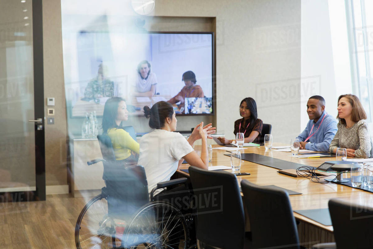 Business people talking and video conferencing in conference room ...