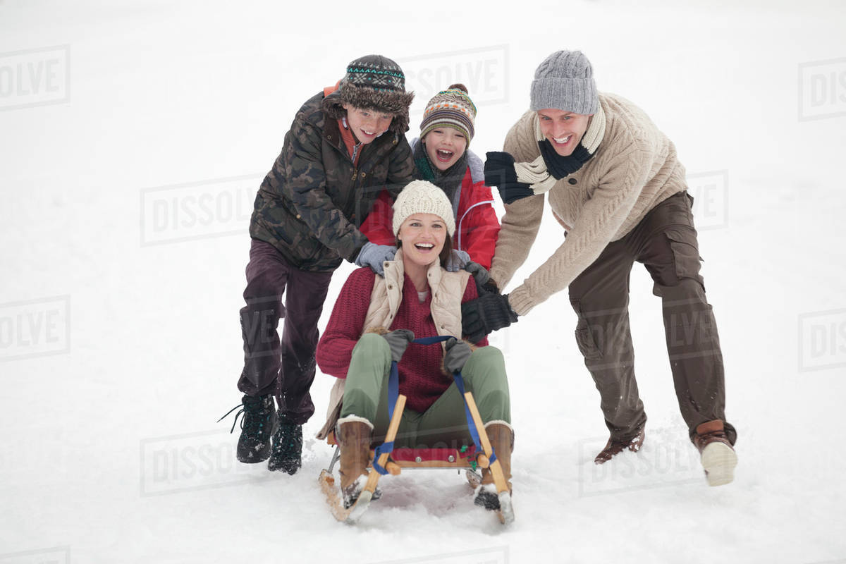 Happy family sledding in snow - Royalty-free Stock Photo | Dissolve