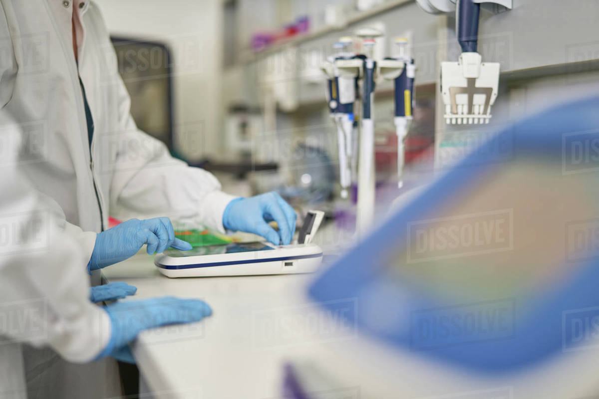 Scientists in rubber gloves using equipment in laboratory - Royalty ...