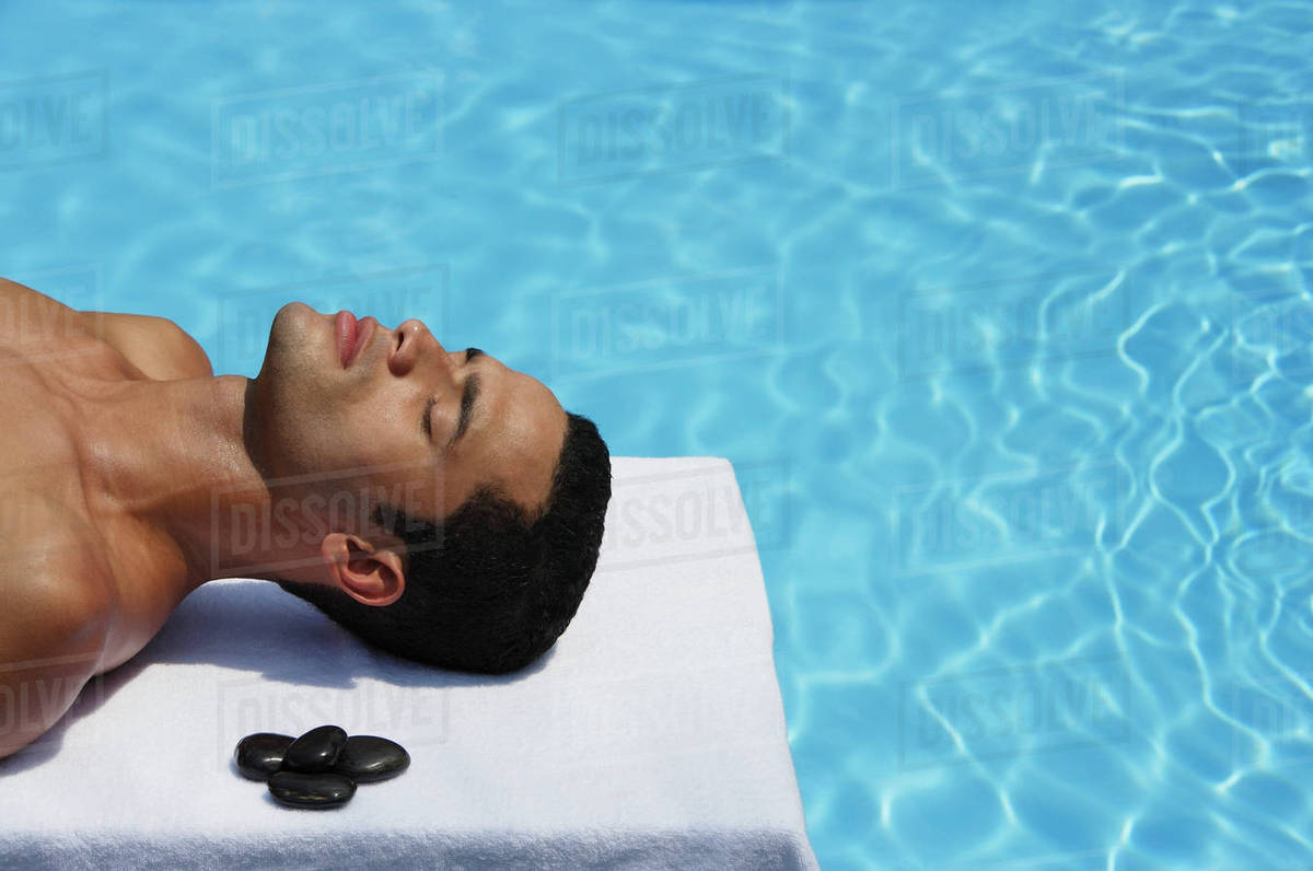 Man lying by pool - Royalty-free Stock Photo | Dissolve